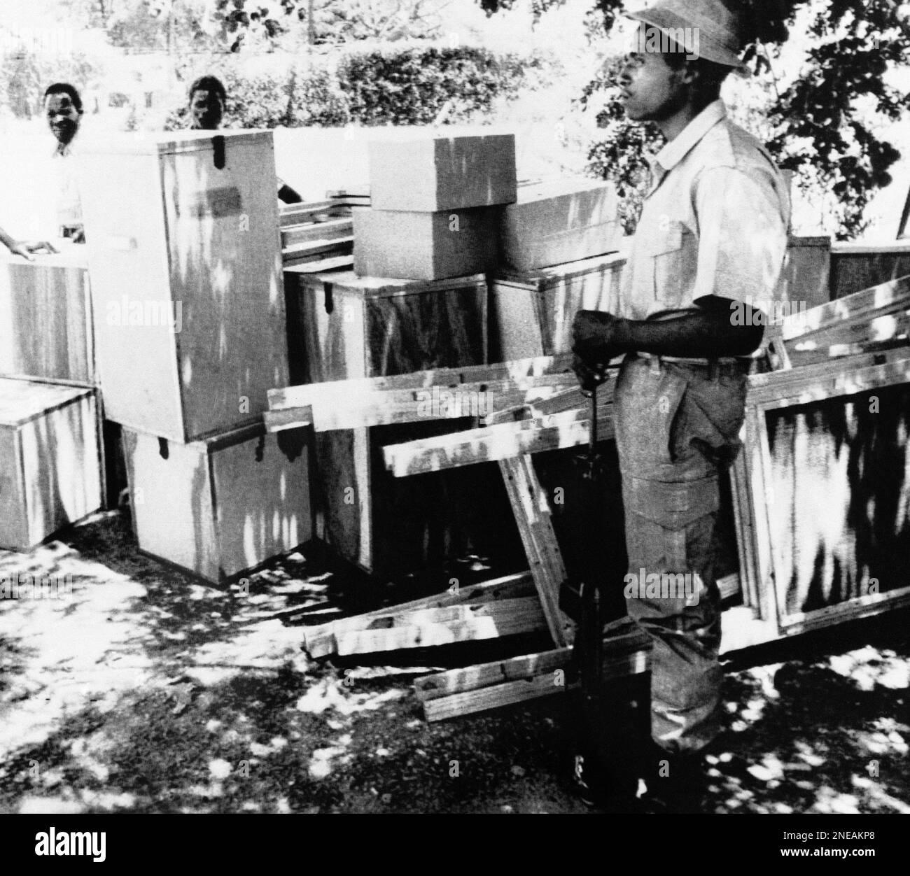 An armed Rhodesian guard stands next to a pile of voting boxes after ...