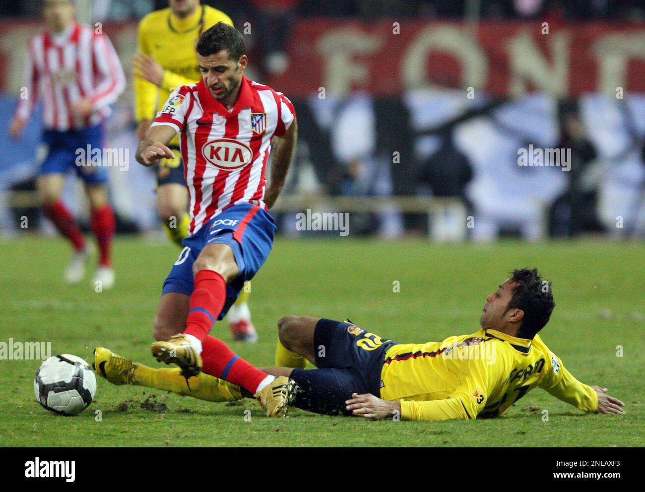 Atletico de Madrid's Simao Sabrosa from Portugal, left, is tackled by ...
