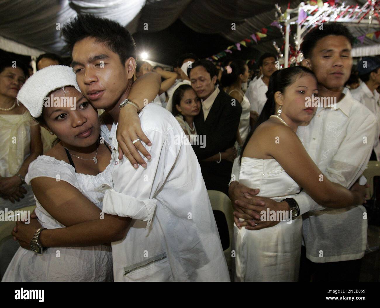 Filipino couples hug each other during a mass wedding ceremony on ...