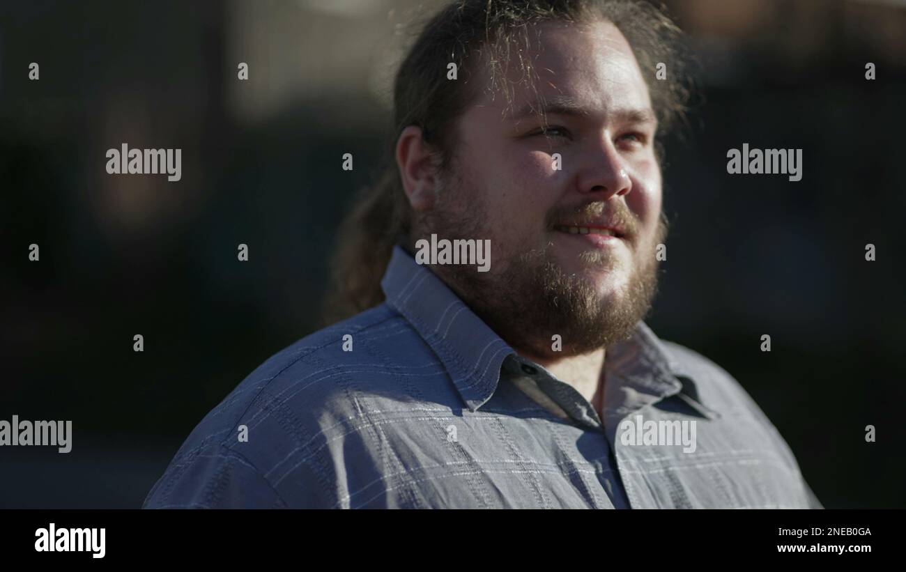 Close up face of a young overweight happy caucasian male walks forward ...