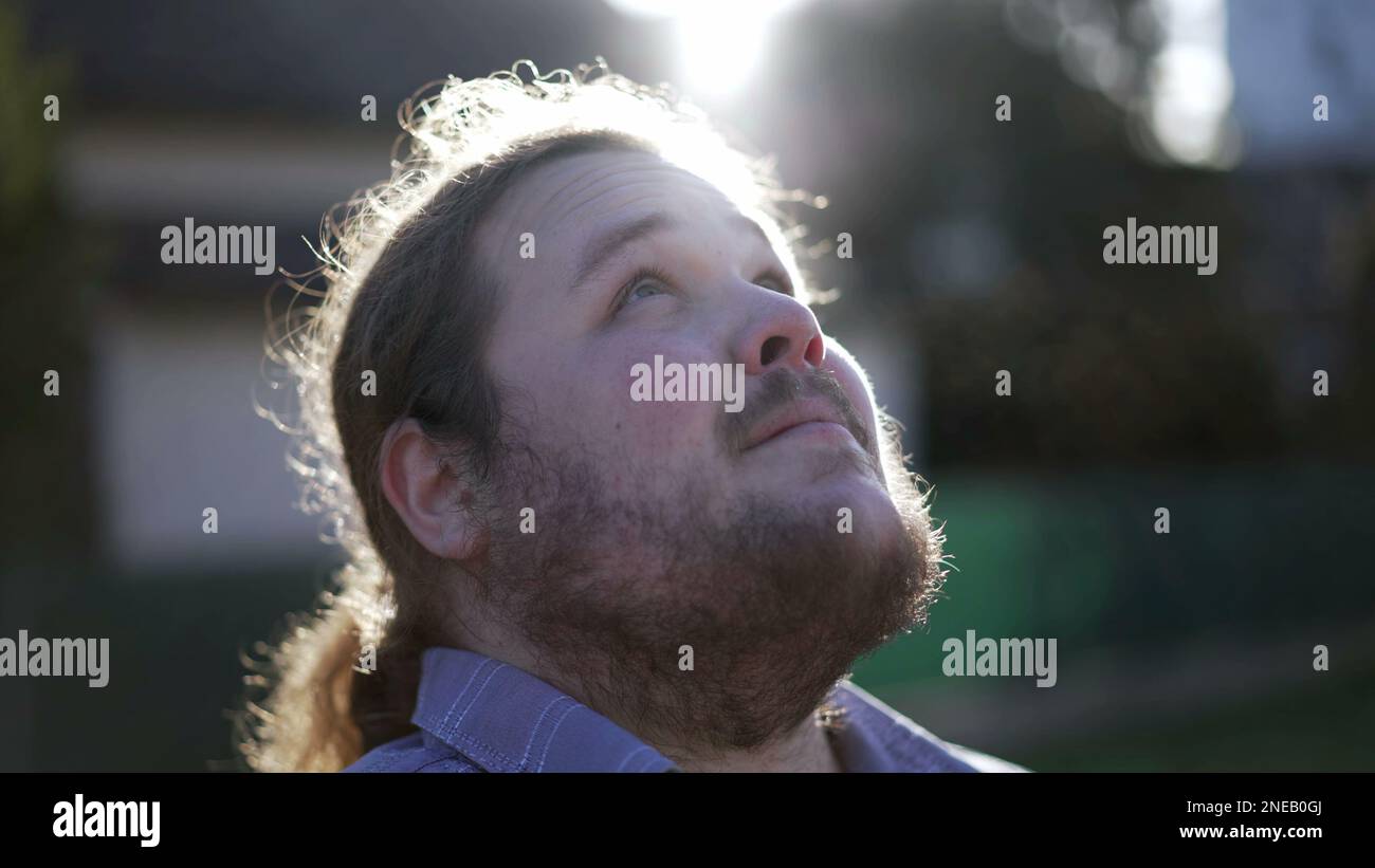 Happy contemplative young man opening eyes to sky with HOPE and FAITH ...