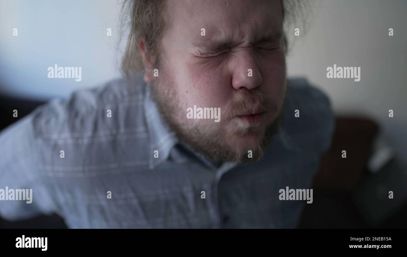 One fat guy having back pain when getting up from couch indoors. A ...