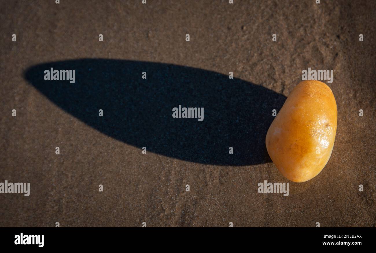 A large semi-translucent Quartz pebble casts a long shadow on the beach ...