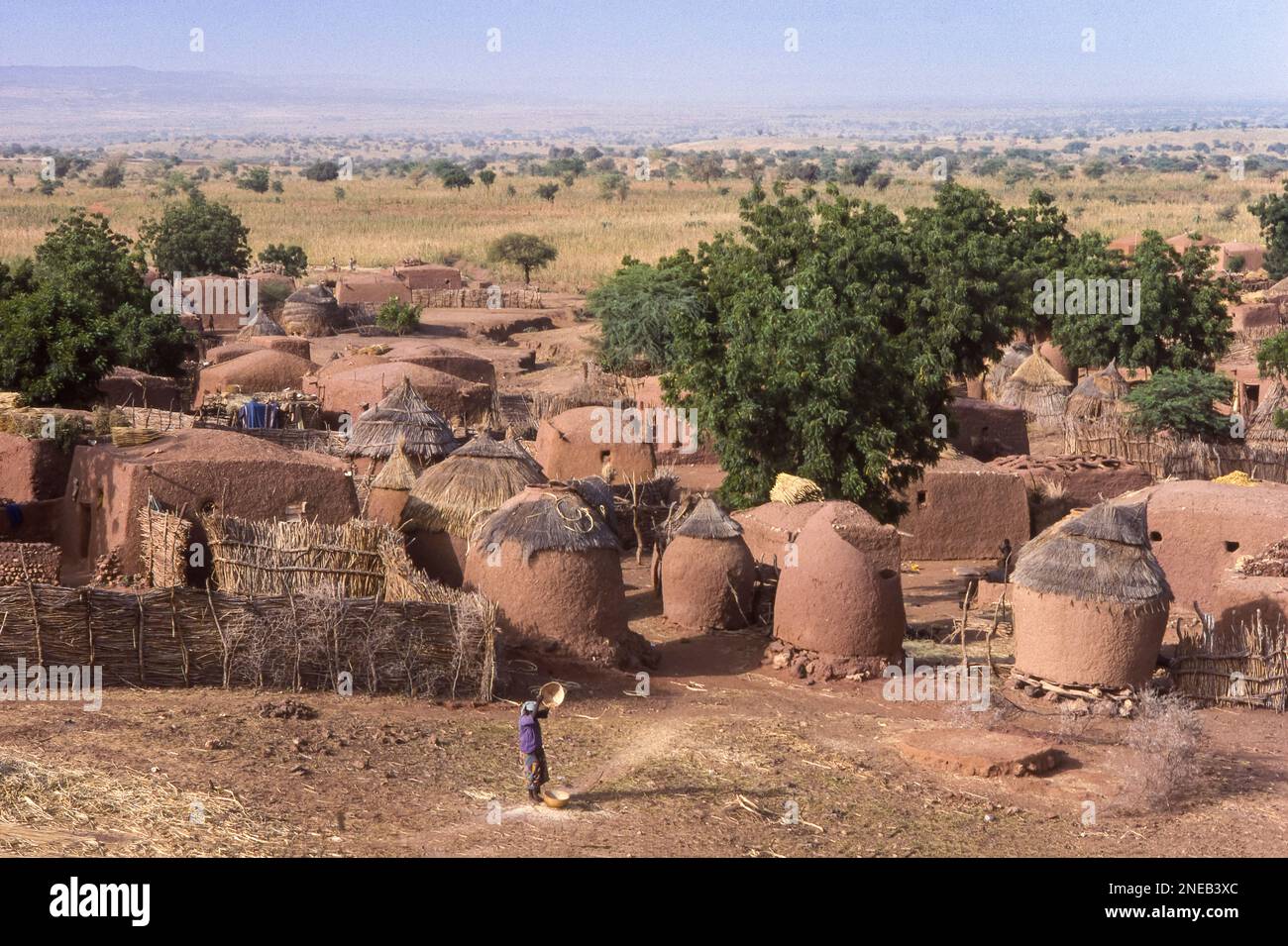 Niger, woman separates the chaff of the millet by hand just outside her ...