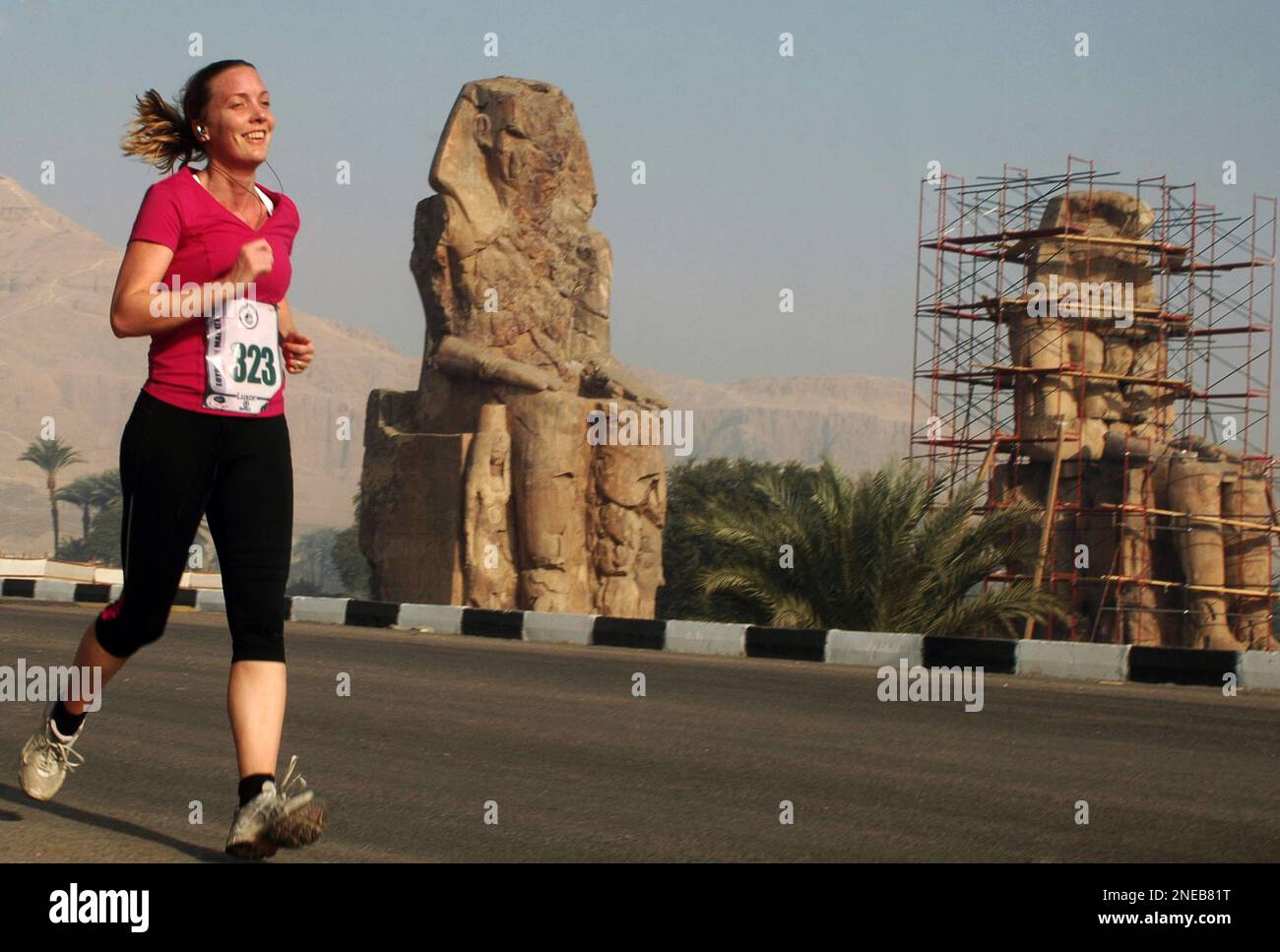 A female runner passes by Pharaonic monuments as she competes in the ...
