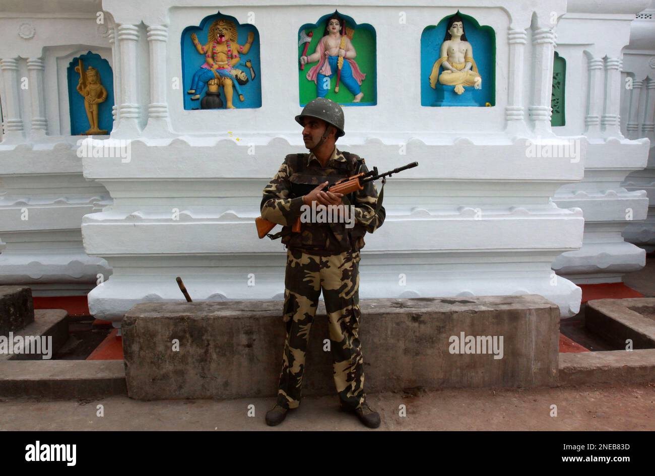 A security personnel stands guard outside a temple during Shivratri ...