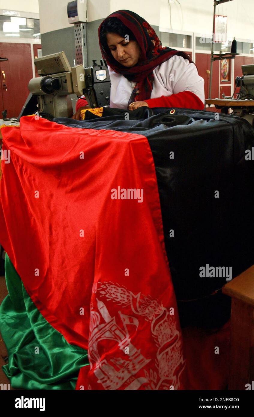 An Afghan woman prepares an Afghan flag at a workshop which produces ...