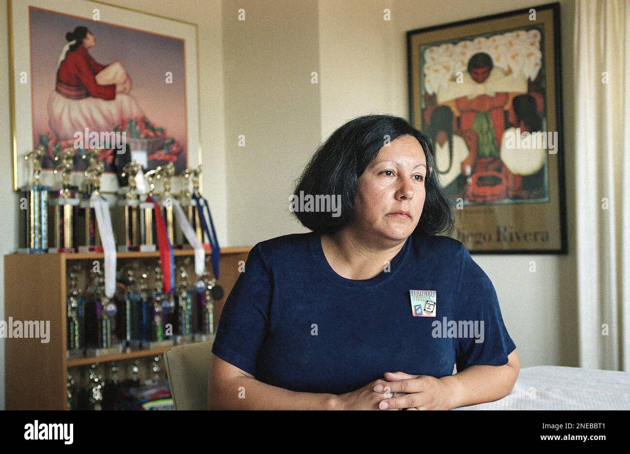 Marie Rose Ortega sits in front of her son's medals and trophies for ...