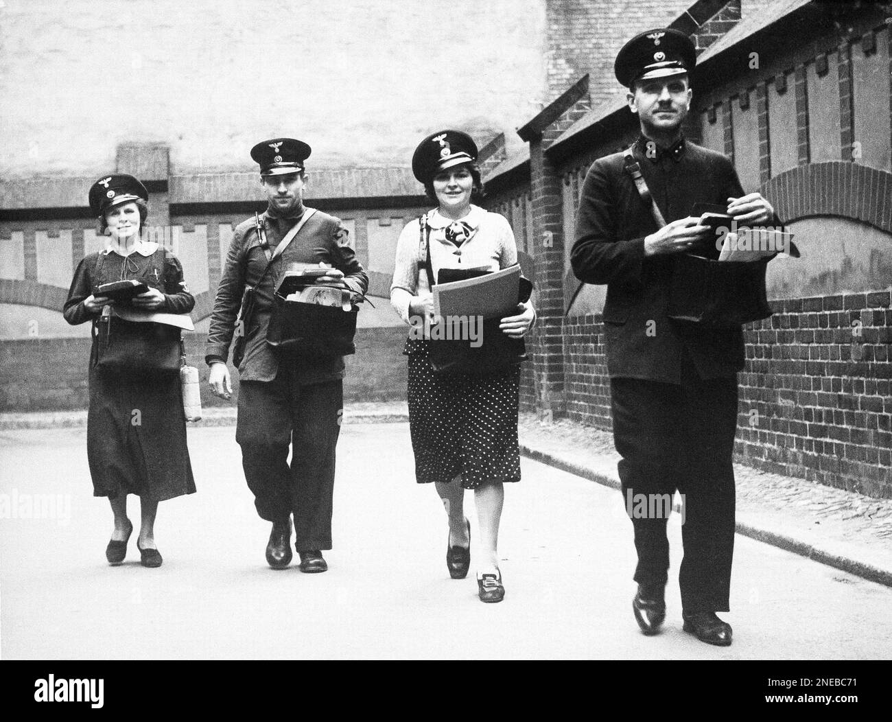 Two women letter carriers leave a Berlin post office with their ...