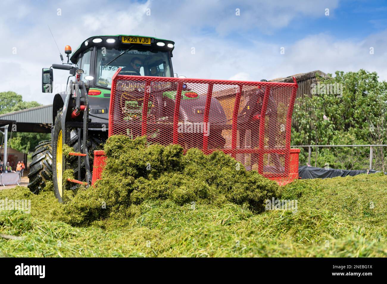 John Deere 6215R with a rear mounted buckrake working on a silage pit ...