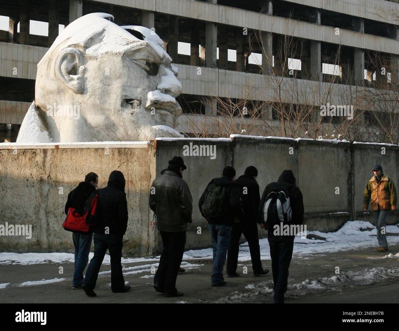 People walk past a deteriorating monument of Soviet state founder ...