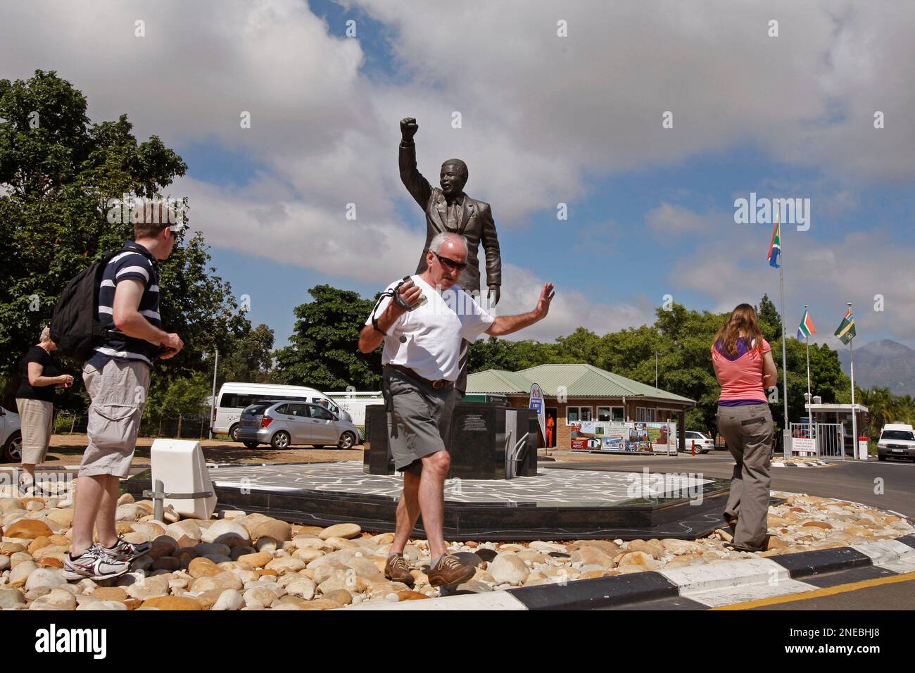 Tourist walk past a statue of former South African President Nelson ...