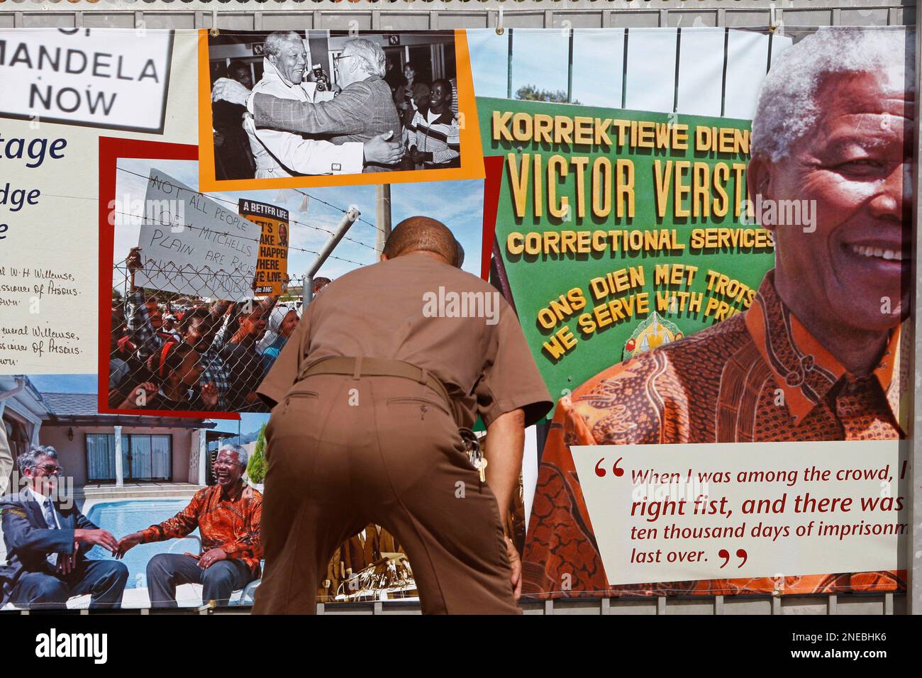 A prison guard looks at posters on the gate at the Groot Drakenstein ...