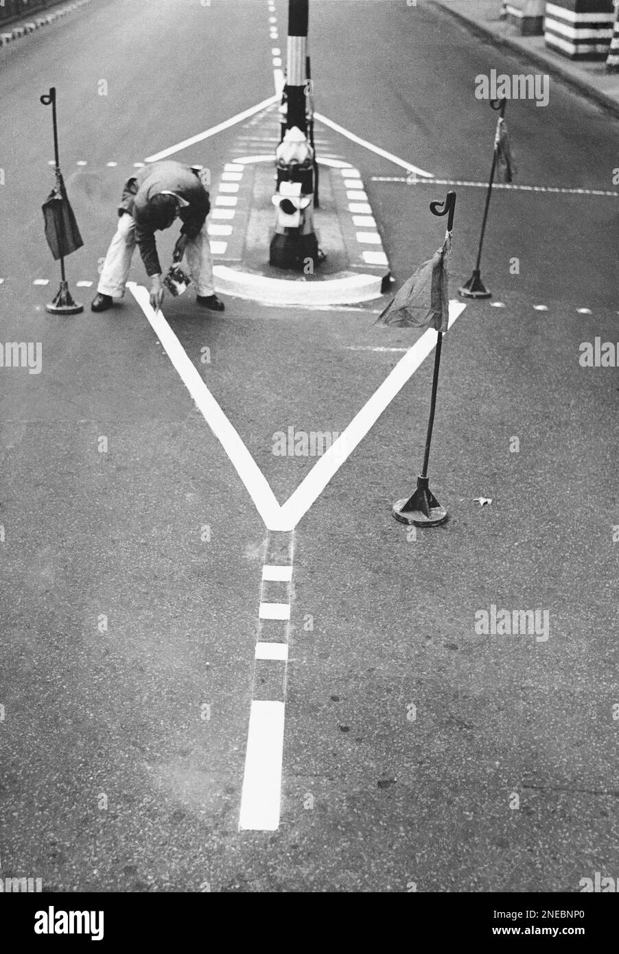 British workman painting a ?Victory V? traffic line around a safety ...