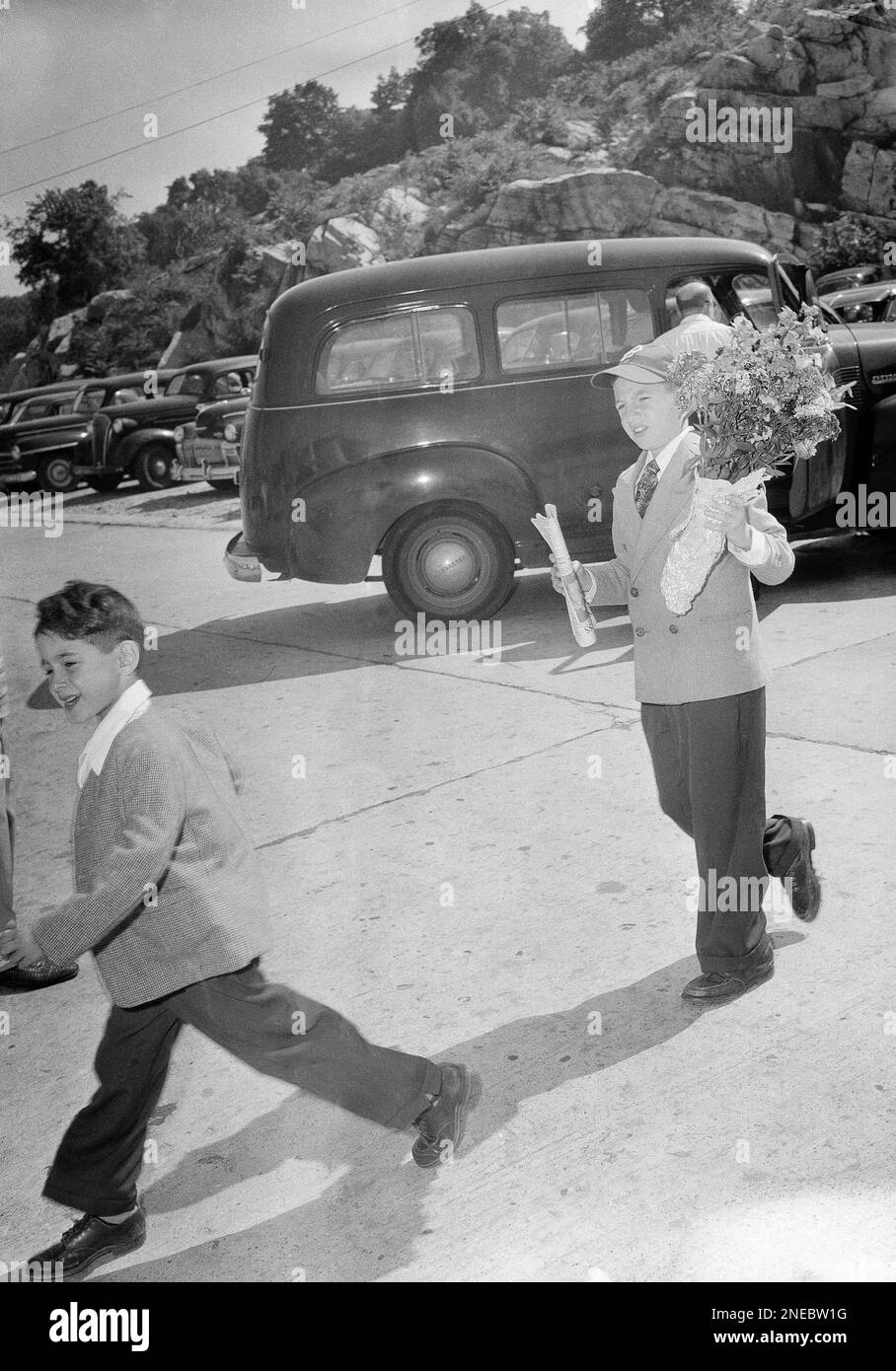 Carrying a bouquet of Flowers, Michael Rosenberg (right), 10, follows ...