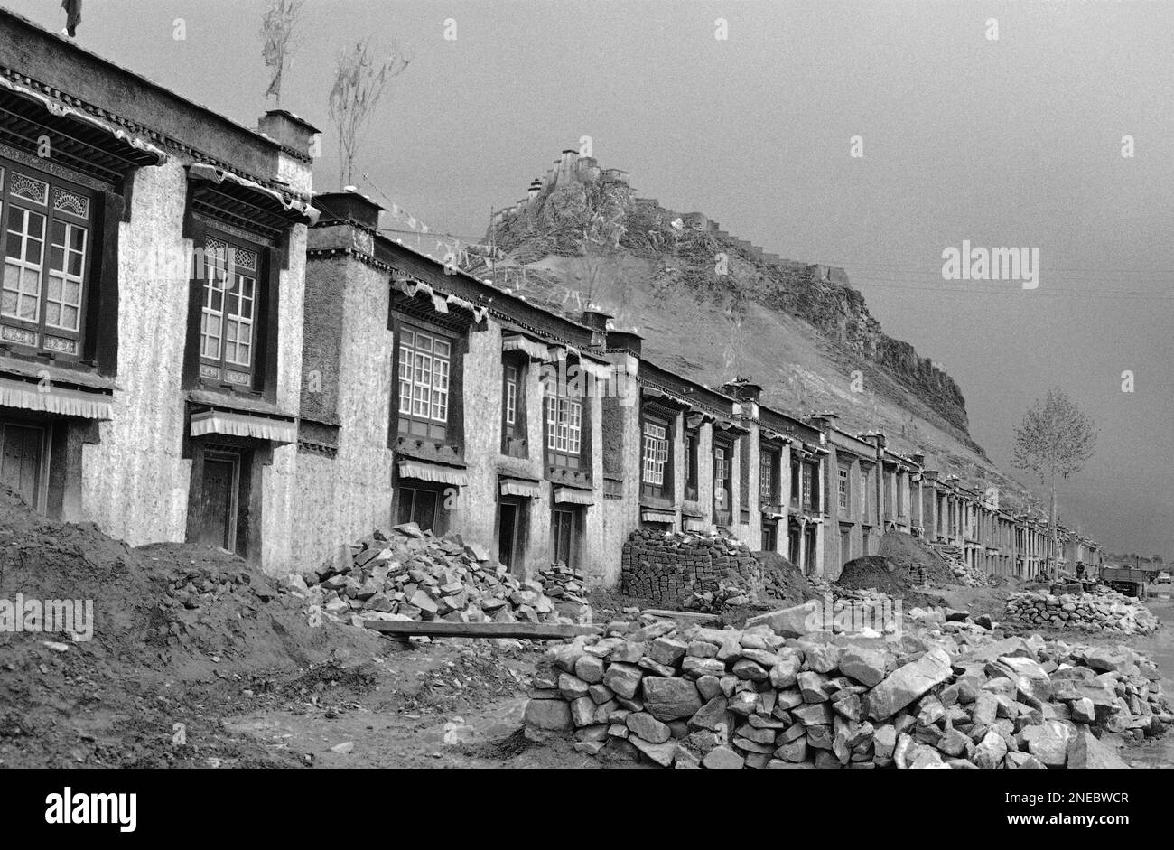 Beneath an ancient fortress, new buildings in an old style rise along ...
