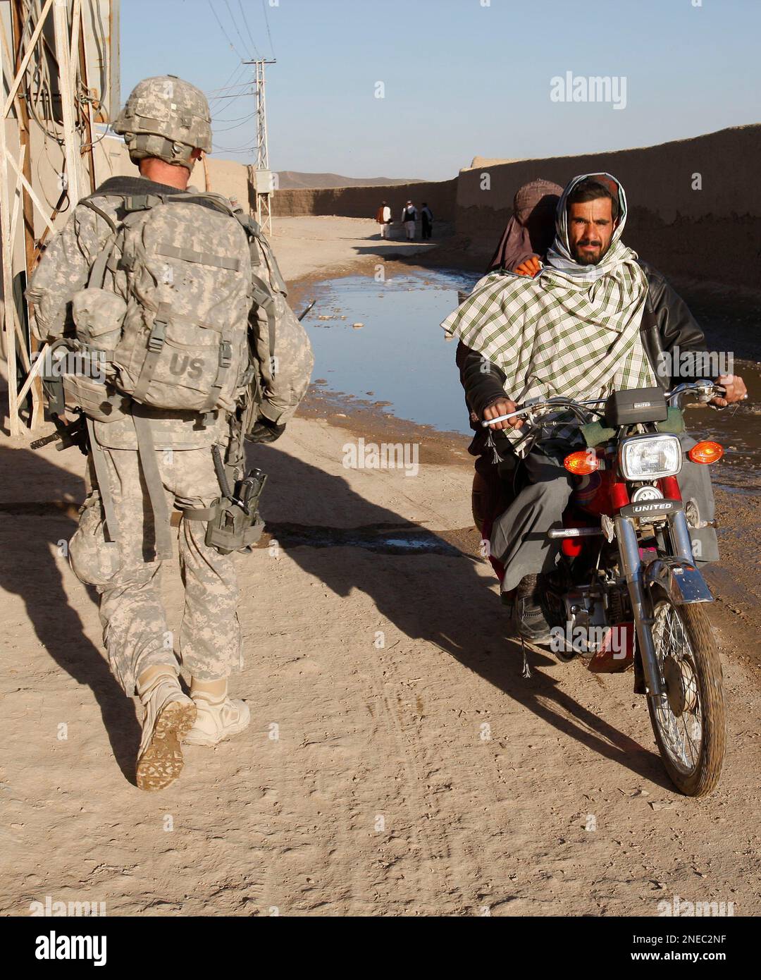 In this photo made Jan. 15, 2010, Afghan men on a motorcycle pass a ...