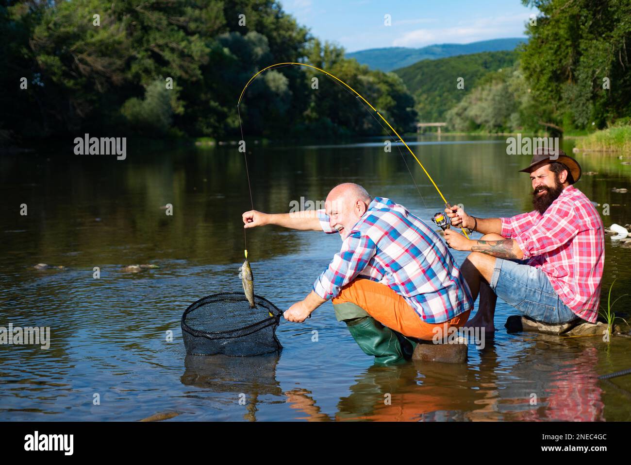 Catching fish. Two men friends fishing. Flyfishing angler makes cast ...