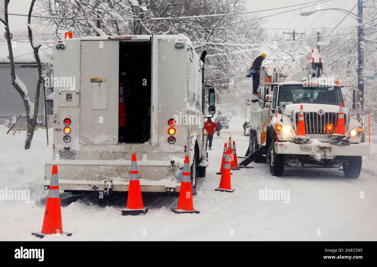 Pepco employees work aboard their service trucks to restore electric ...