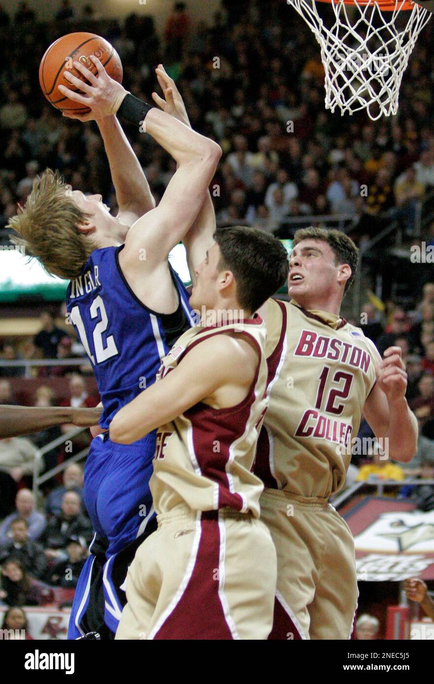 Duke's Kyle Singler, left, makes a shot over the arms of Boston College ...
