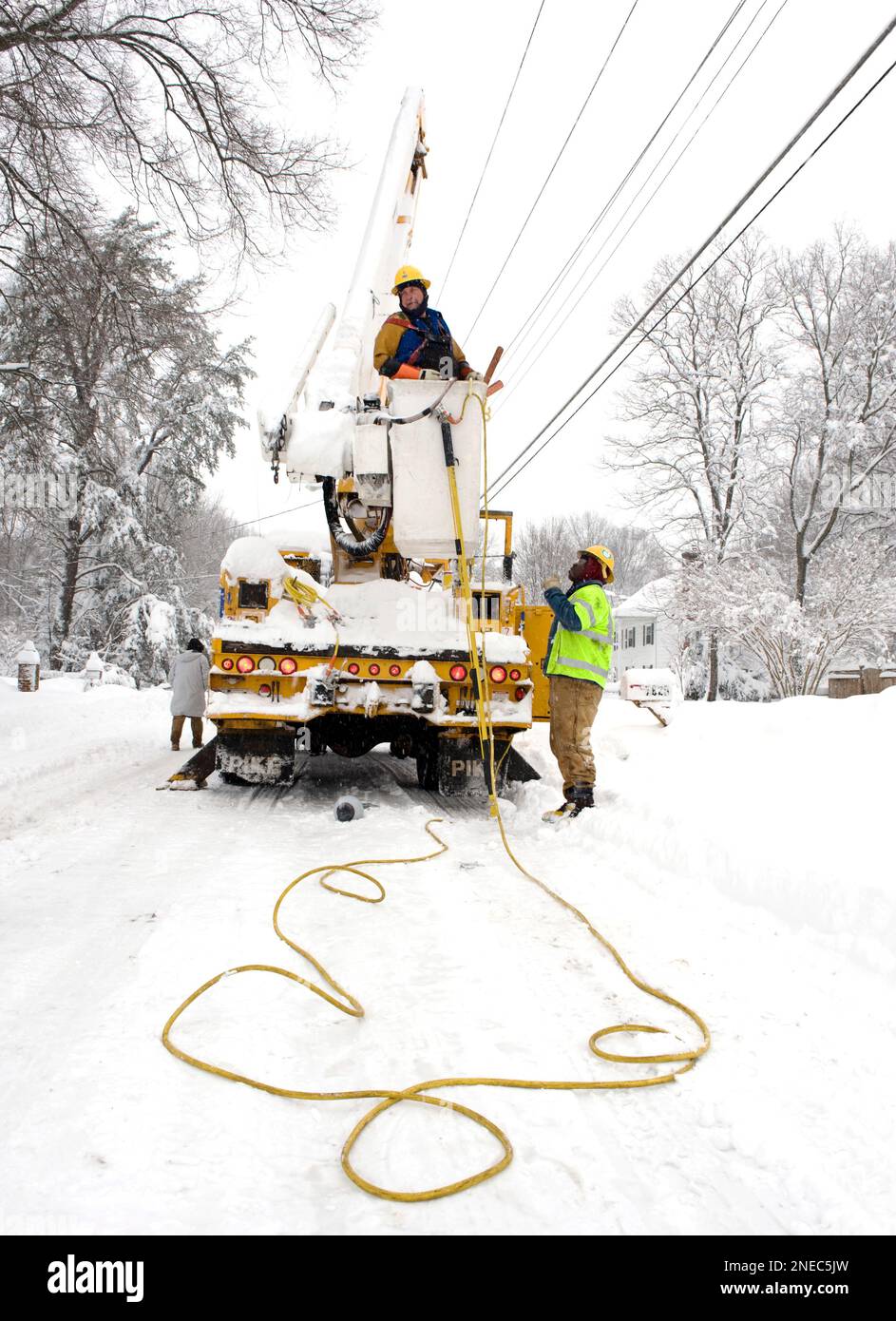 A line crew from Pike Electric prepares to repair a downed power line ...