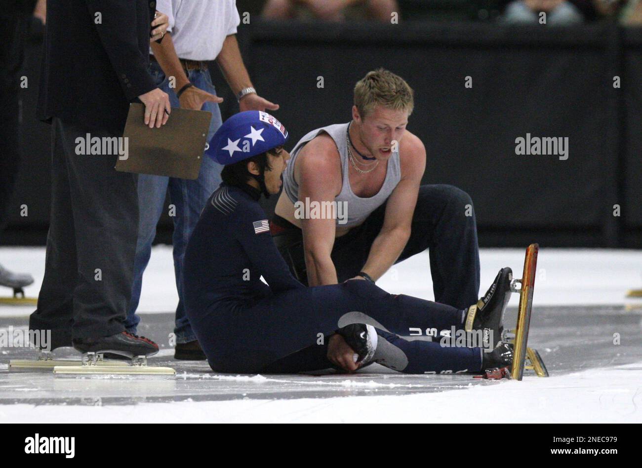 J.R. Celski is tended by skater Walter Rusk after cutting his left leg ...