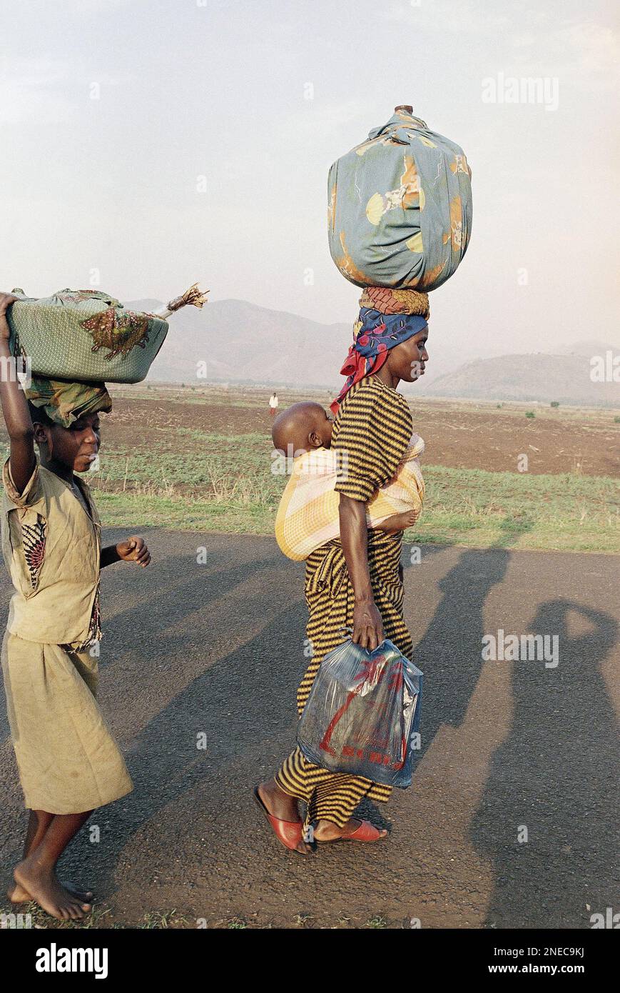 A Hutu peasant with her two children cross the Burundi border into ...