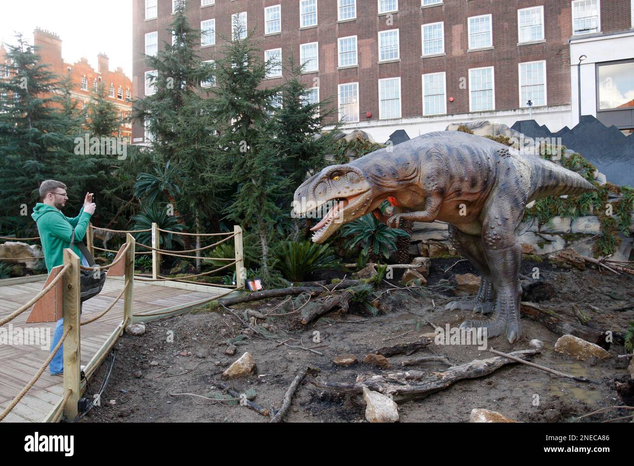 A visitor photographs an animatronic Megalosaurus on display at the ...
