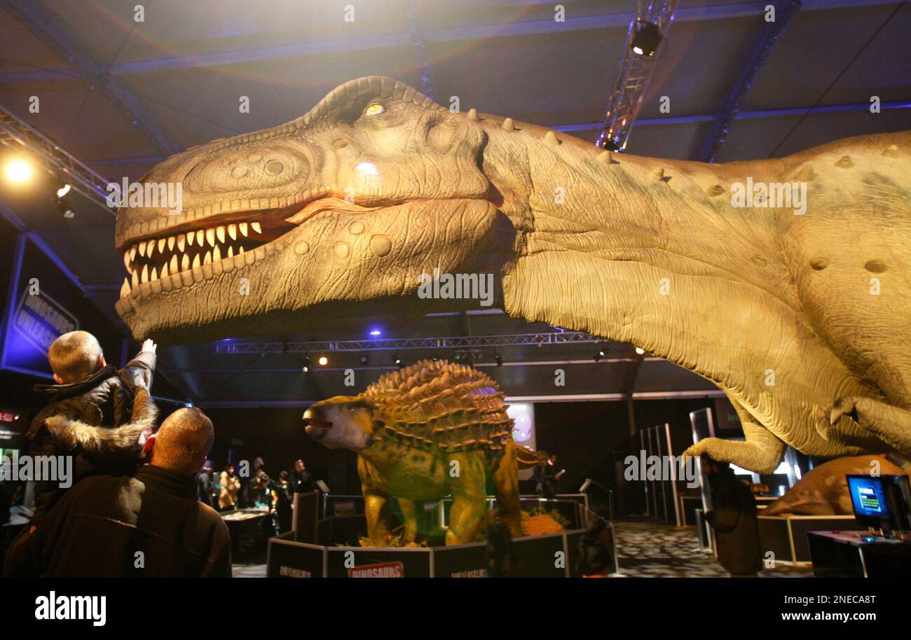 A visitor touches an animatronic Tyrannosaurus rex on display at the ...