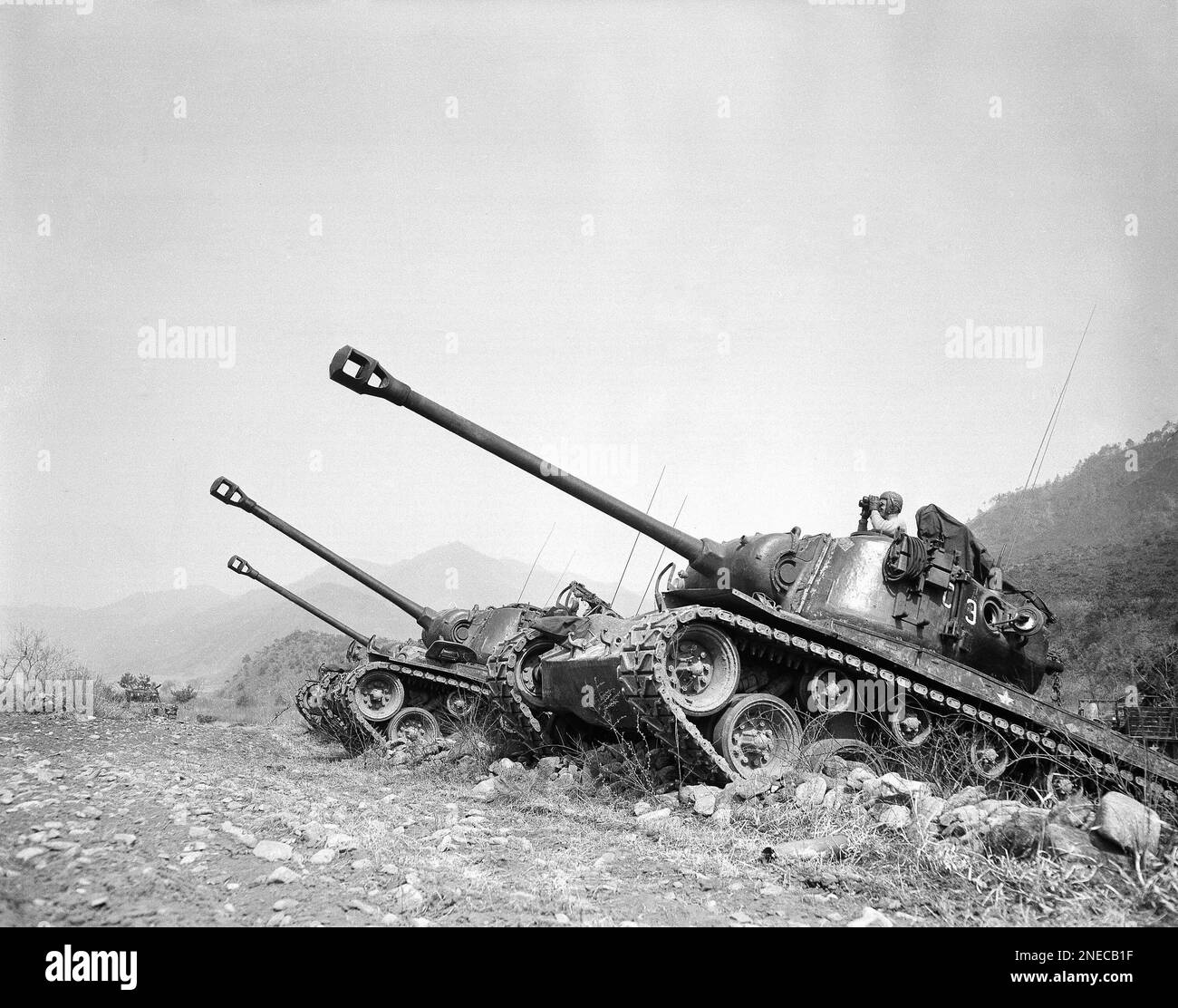 A tank captain, right, uses field glasses to scan targets as his and ...