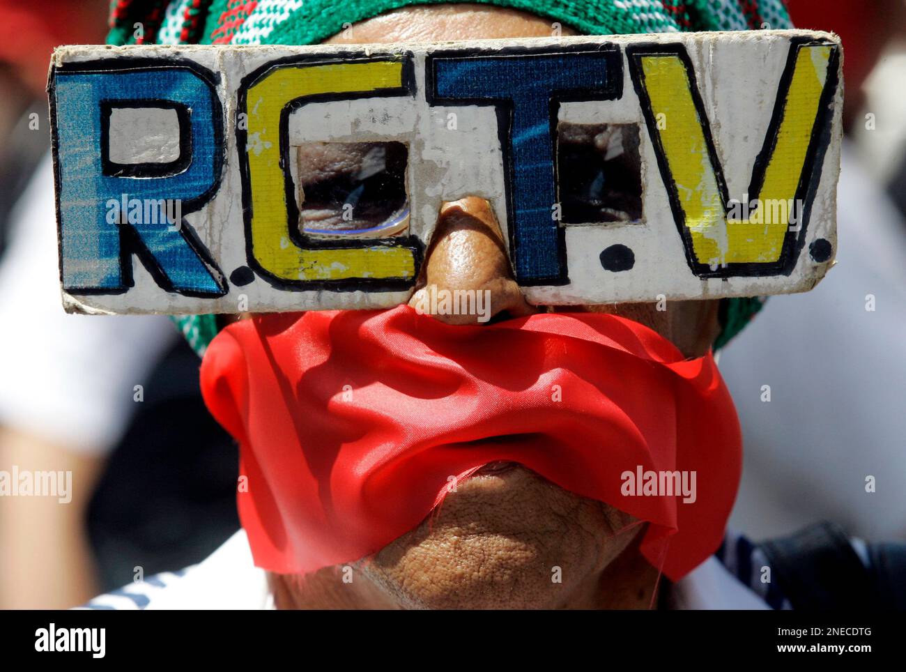 A woman with her mouth covered with a red cloth and wearing glasses ...