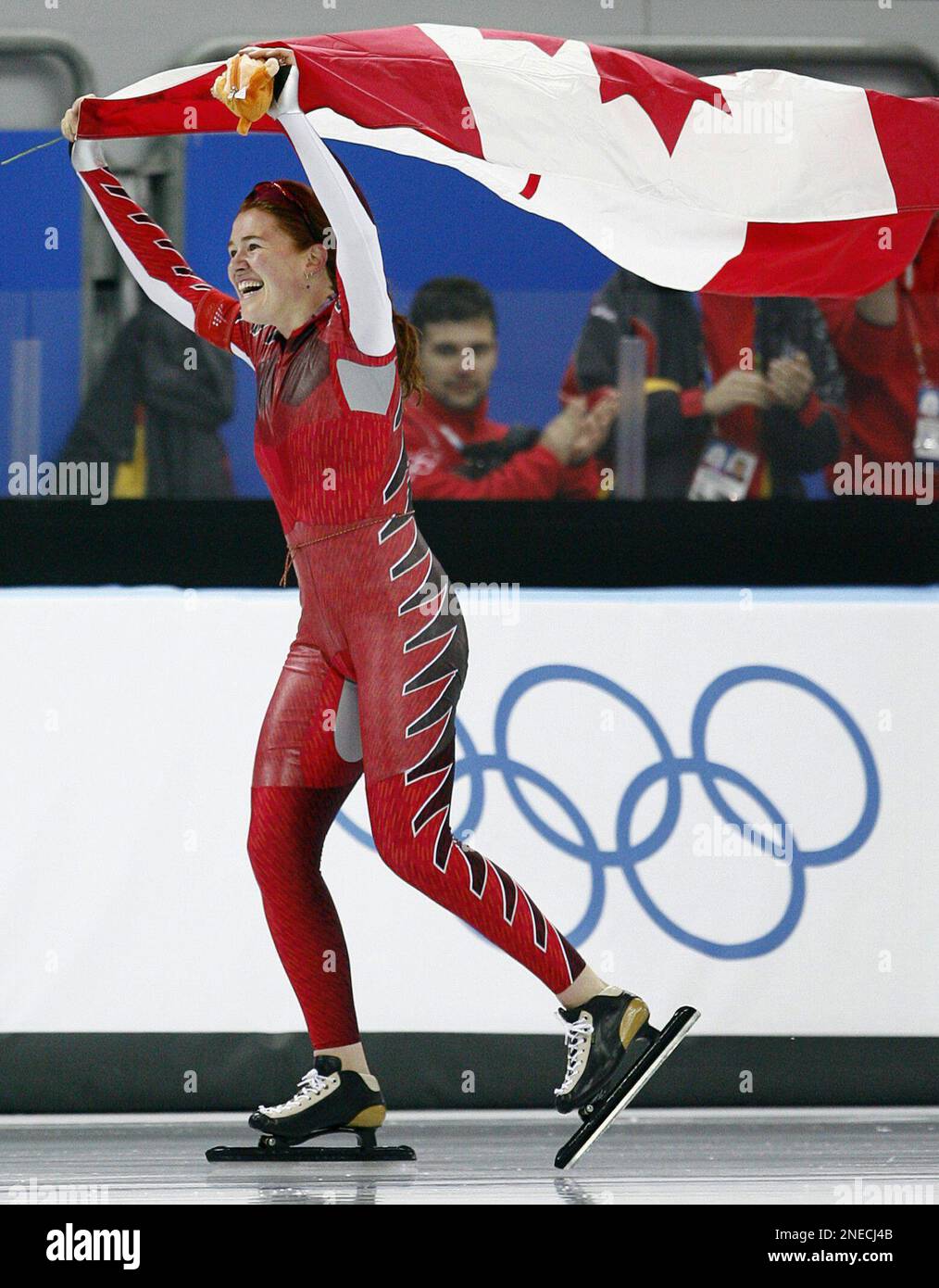 Canada's Clara Hughes skates her victory lap with the Canadian flag ...