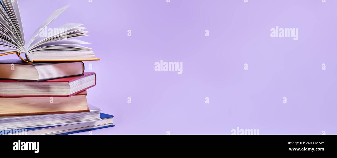 Close-up of a stack of books with one open book on top Stock Photo - Alamy