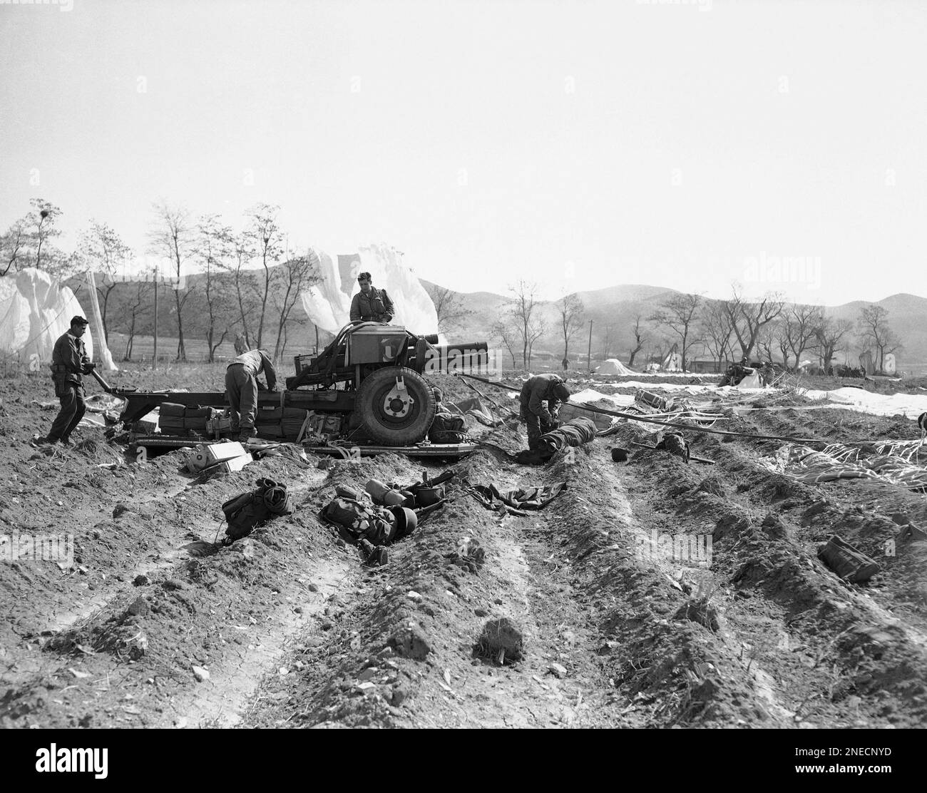 A field gun is unpacked from its tight housing by GIs after it was ...