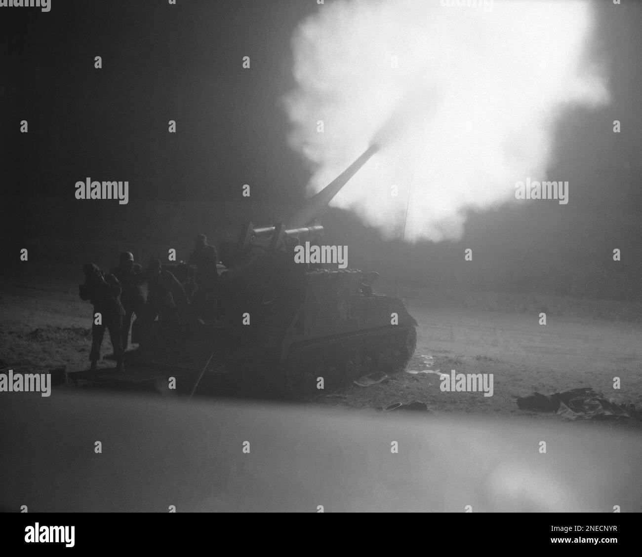 Allied artillerymen shield their ears from the thunderous blast as they ...