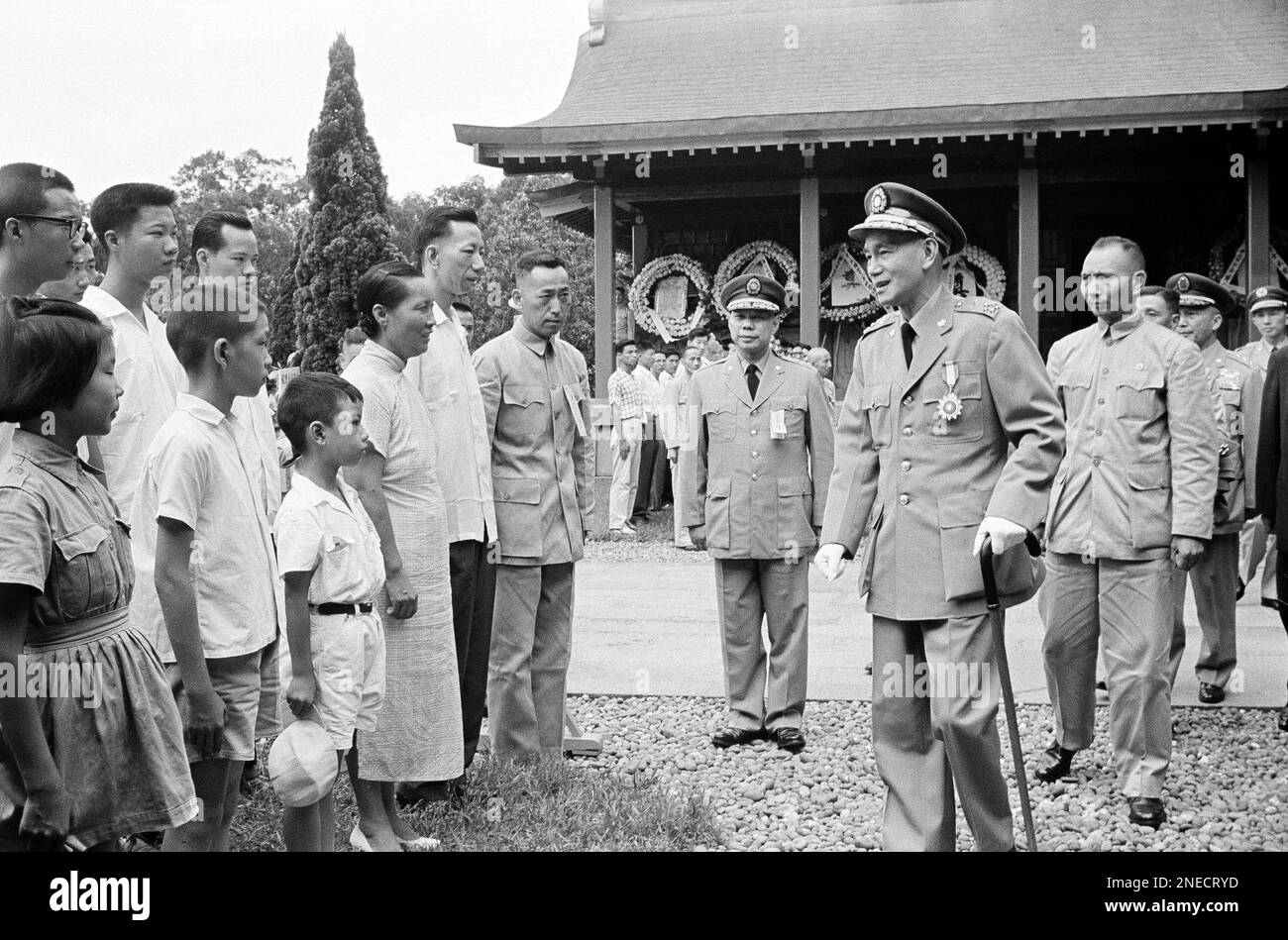 President Chiang Kai-shek, with cane, talks with dependents of dead ...