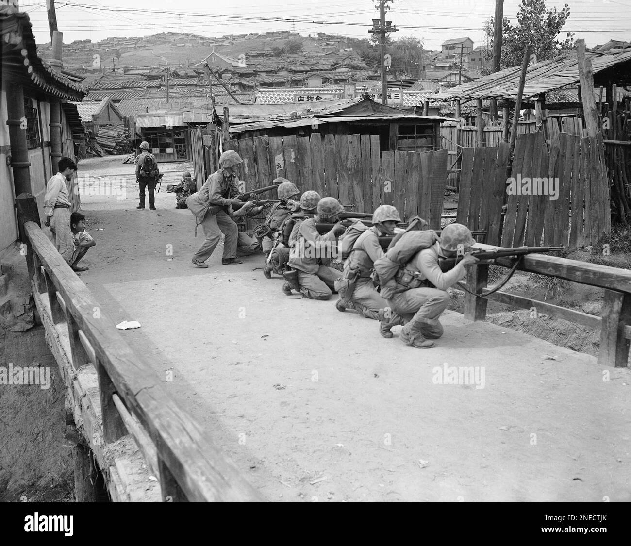 U.S. Marines crouch behind a railing in Seoul on Sept. 27, 1950, as ...
