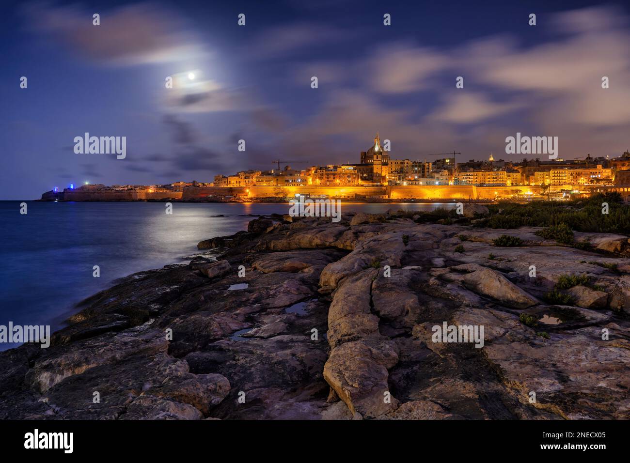 Skyline of Valletta city at night in Malta. View from rocky shore of ...