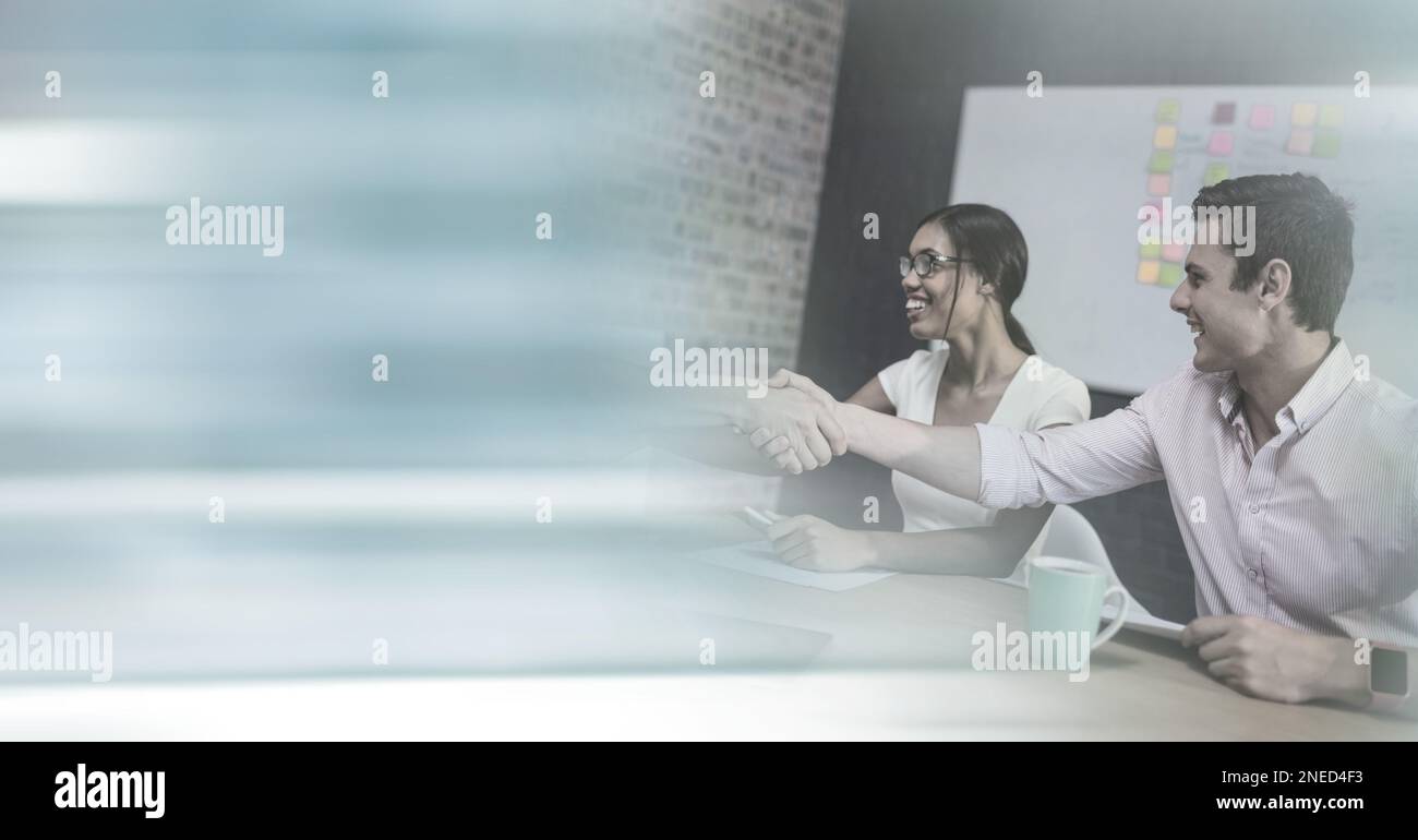 Composition of happy diverse business team shaking hands with motion ...