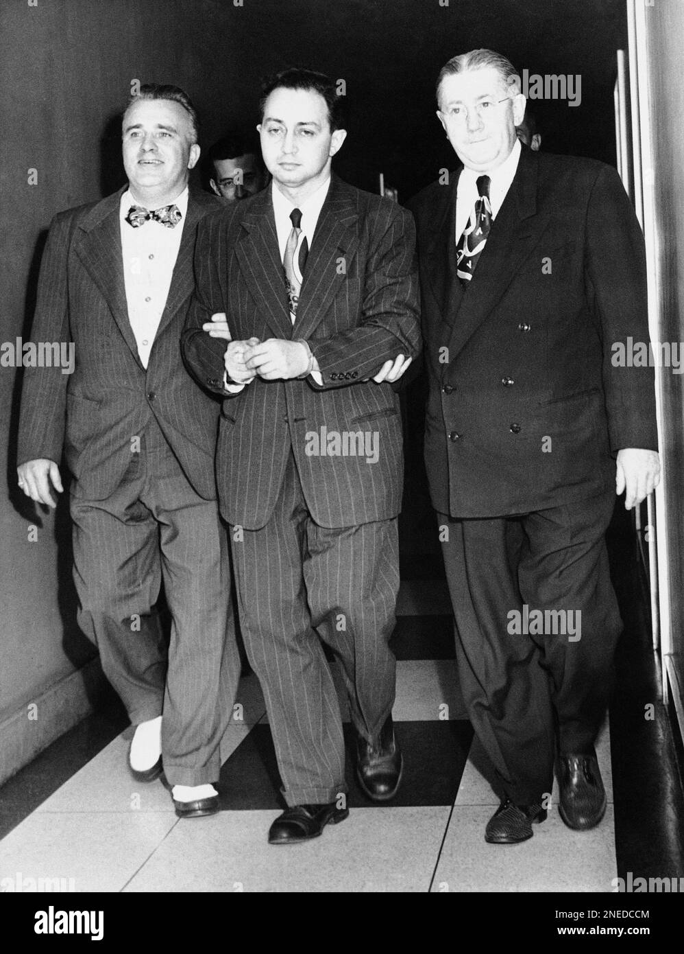 Harry Gold, 39, (center), research chemist, his hands shackled, is led ...