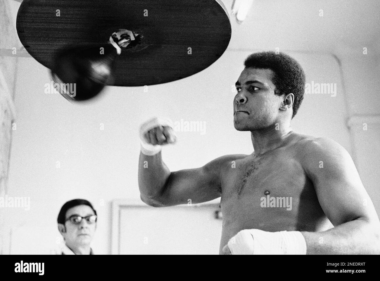 Heavyweight boxer Muhammad Ali works out with a heavy punching bag at ...