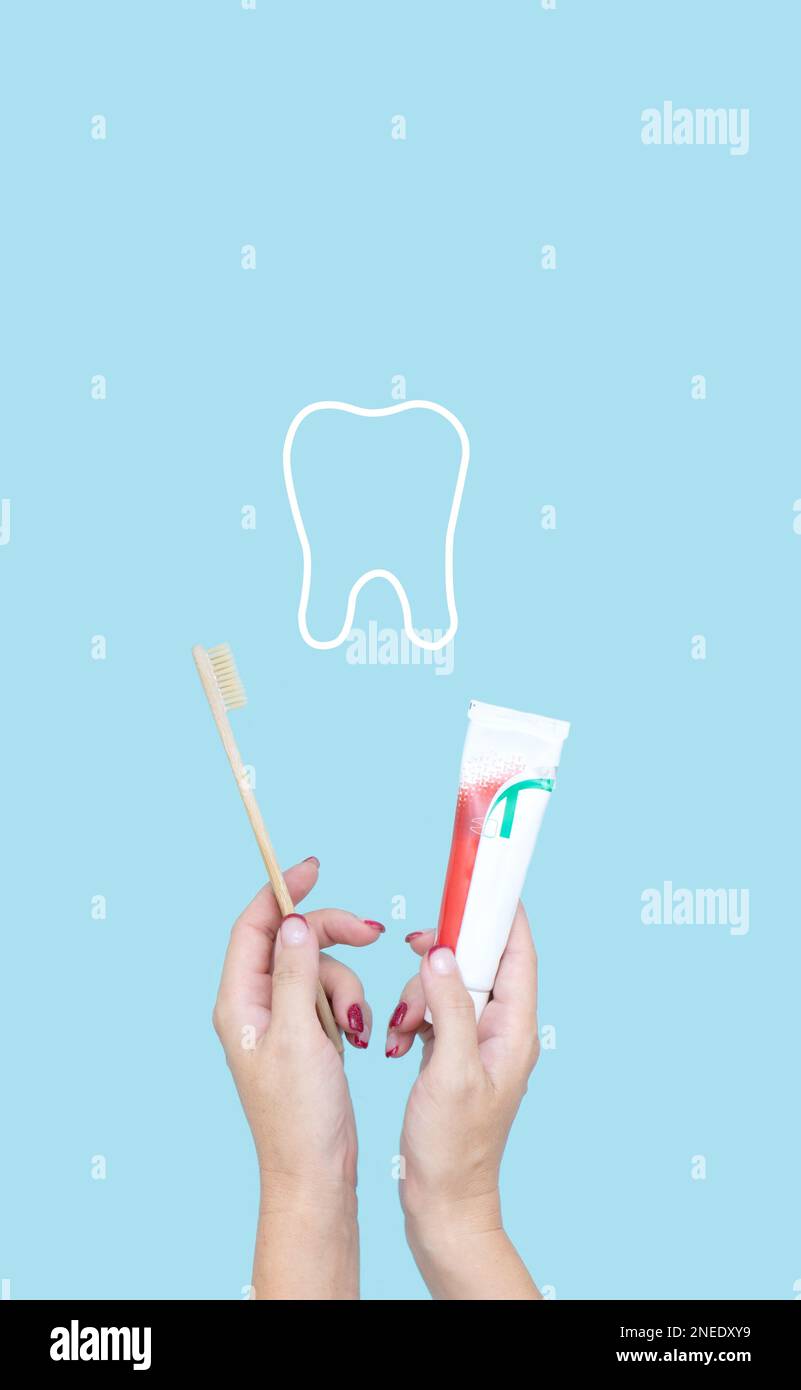 Closeup of a toothbrush and toothpaste in woman hands with thin linear ...