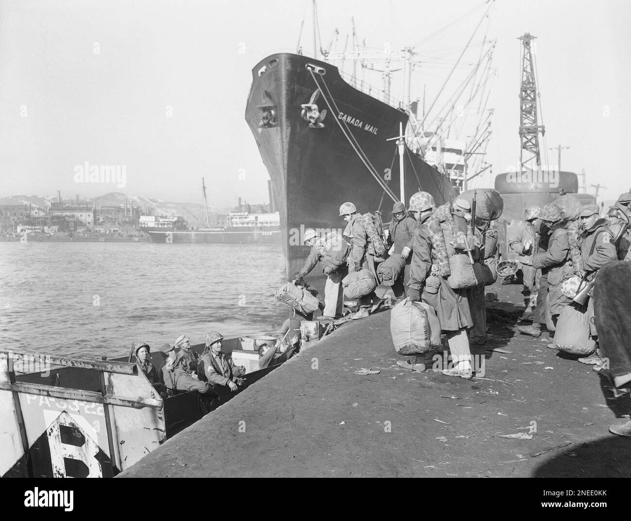Troops board a LCP (landing craft personnel) at a dock in Hungnam ...