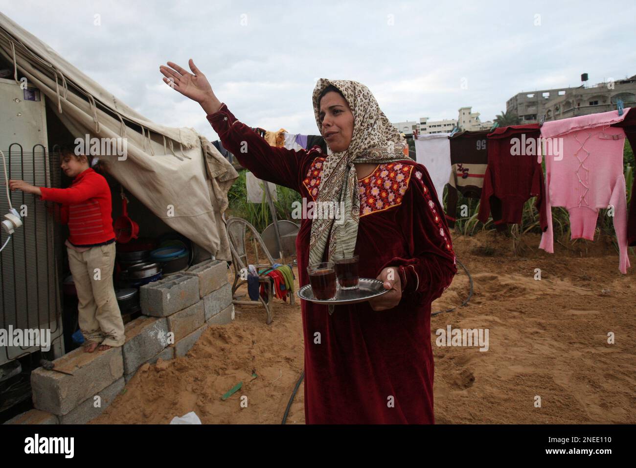 Palestinian Wafaa Awaja, 33, gestures as she carries a tray with cups ...