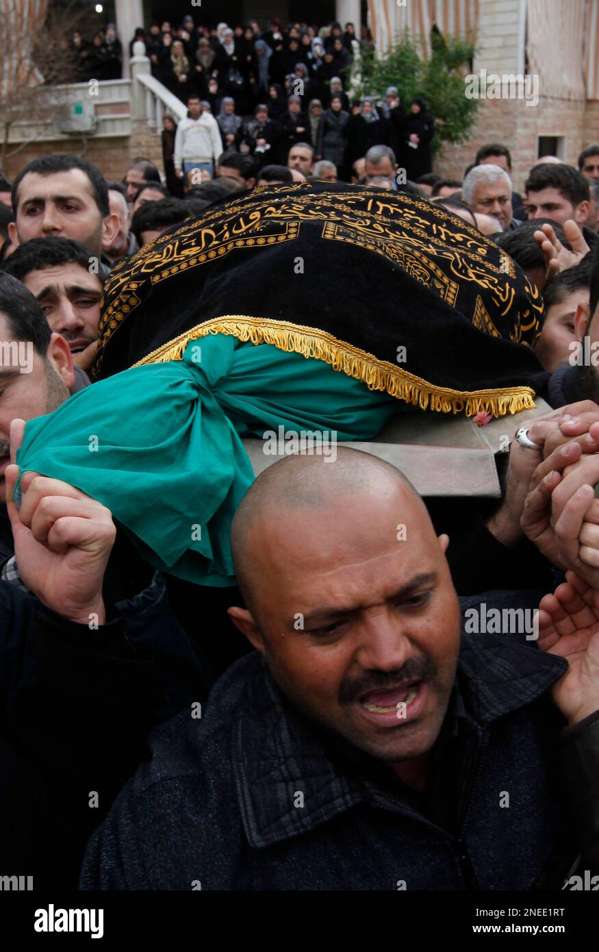 Mourners carry the coffin of prominent businessman Hassan Tajeddine a ...