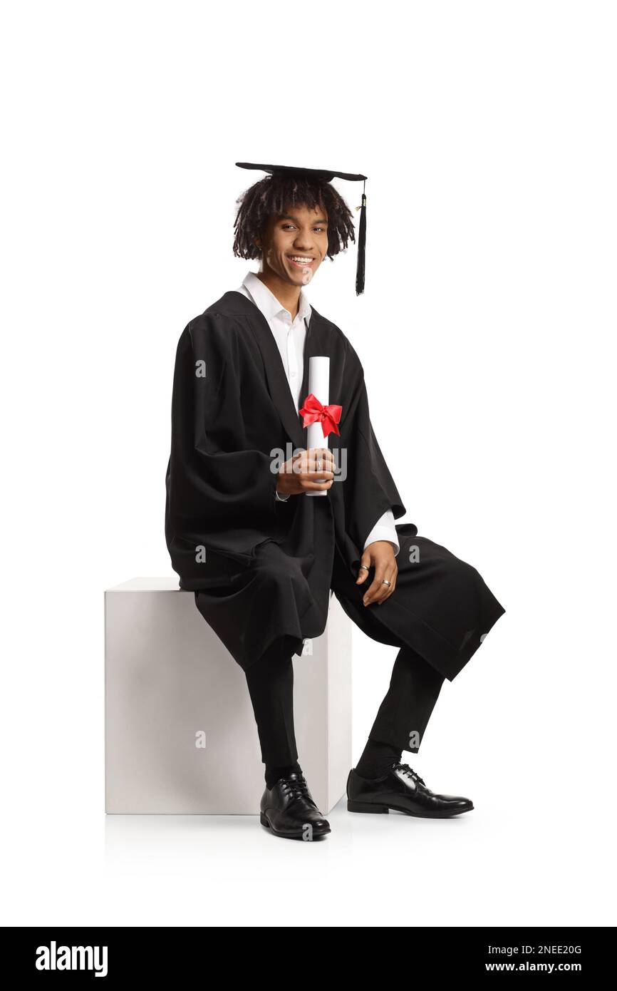 Male african american graduate student in a gown sitting and holding a ...