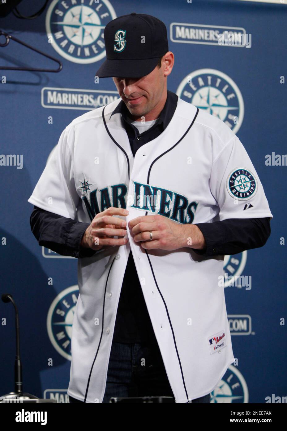 Seattle Mariners pitcher Cliff Lee, buttons his Mariners' jersey during ...