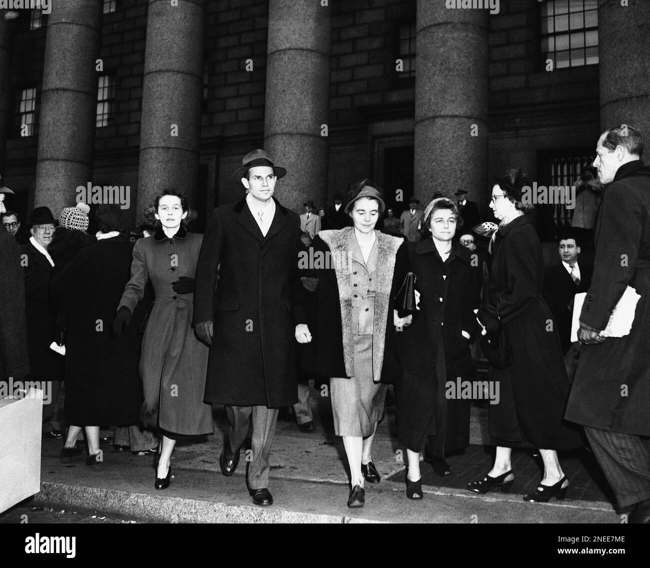 Alger Hiss and his wife, Priscilla, (light coat) walk through crowd ...