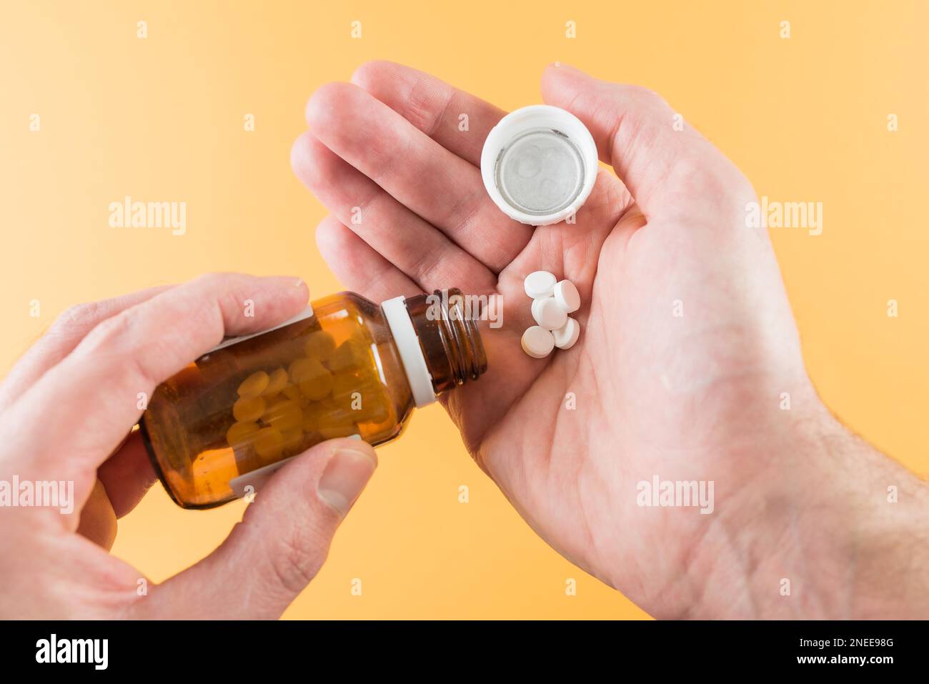 close-up of hands dispensing tablets from pill bottle, medication ...