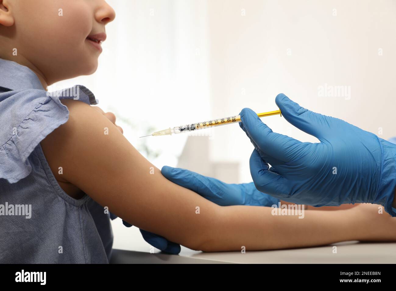 Doctor giving injection to little girl in hospital, closeup ...